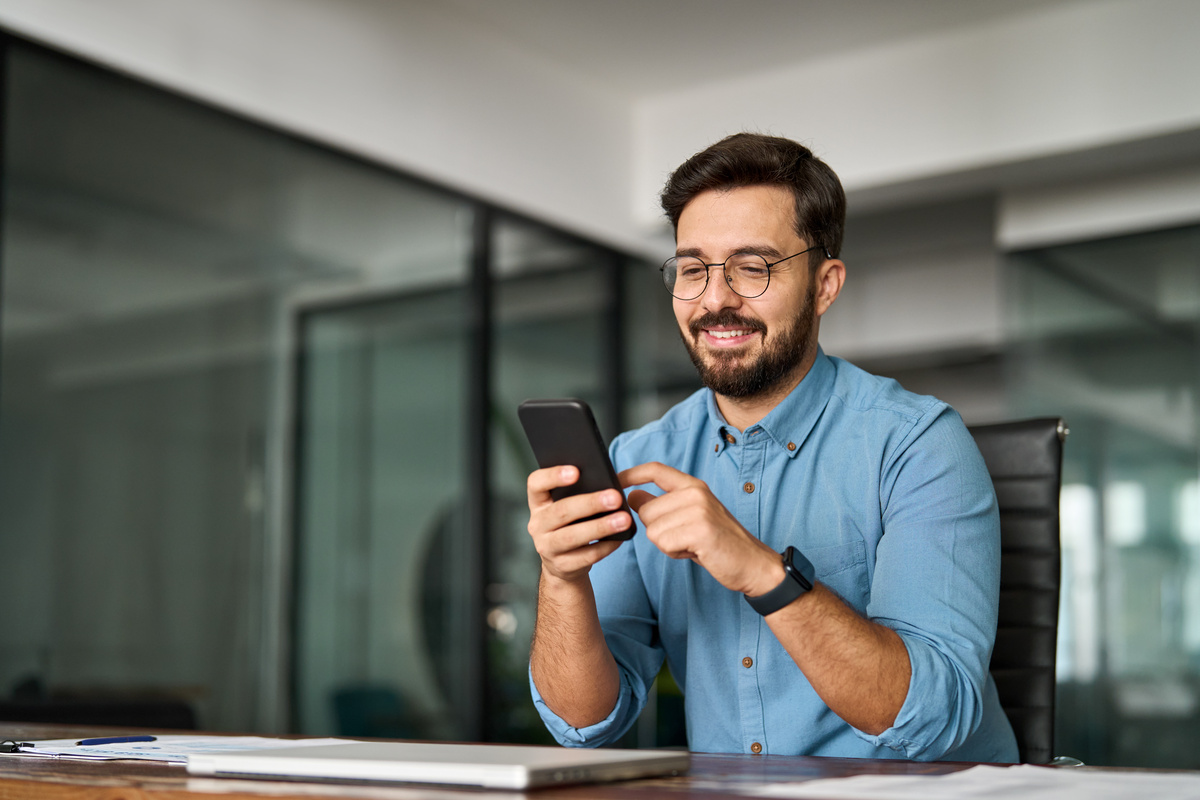 Busy happy young Latin business man holding cell phone working in ...